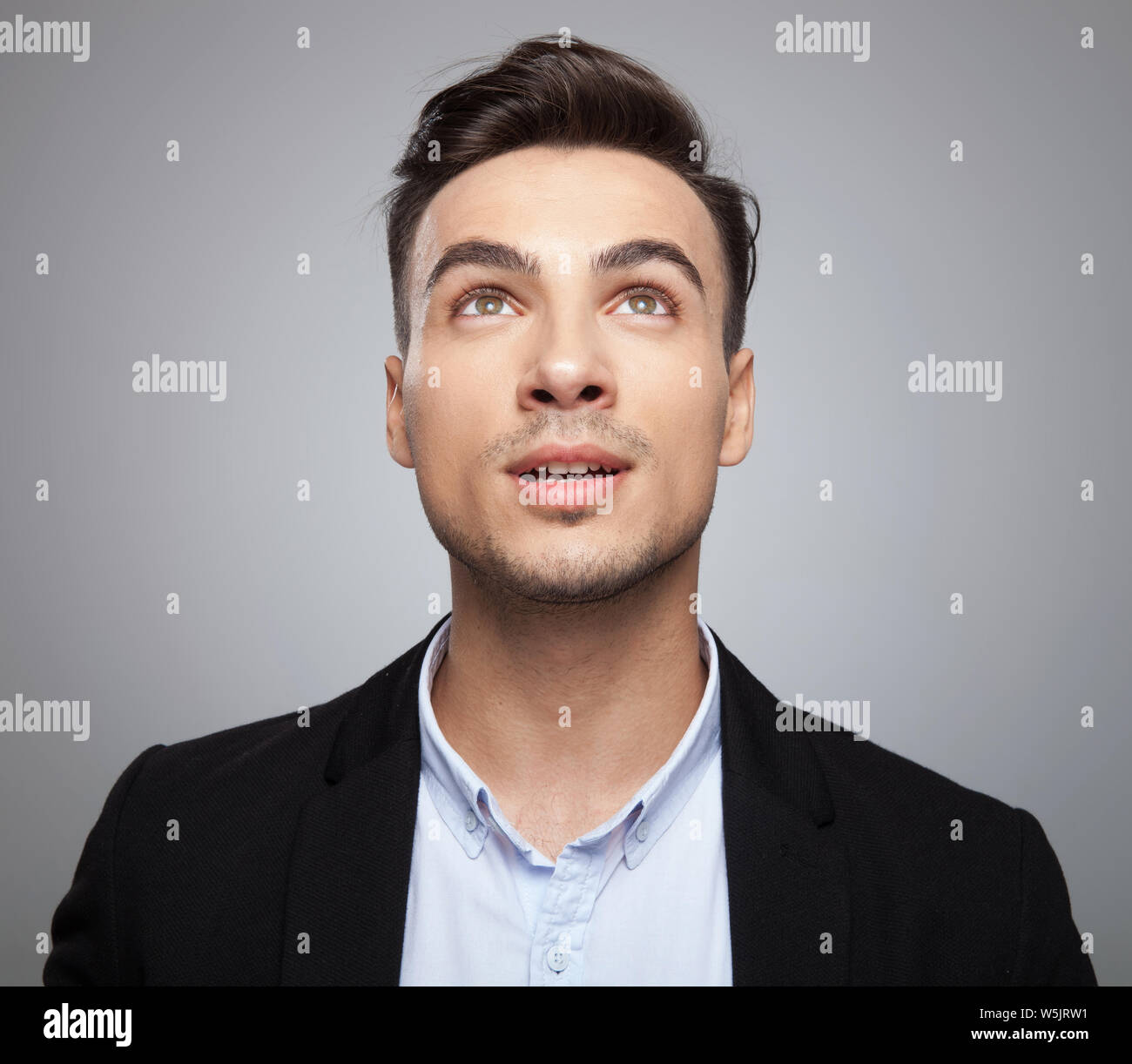 portrait of curious shocked businessman looking up while standing on ...