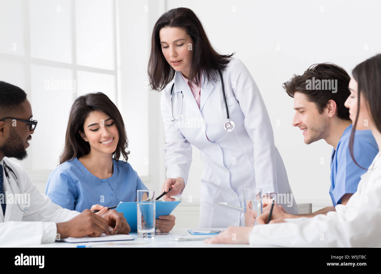 Chief doctor discussing diagnosis with interns and practitioners Stock ...