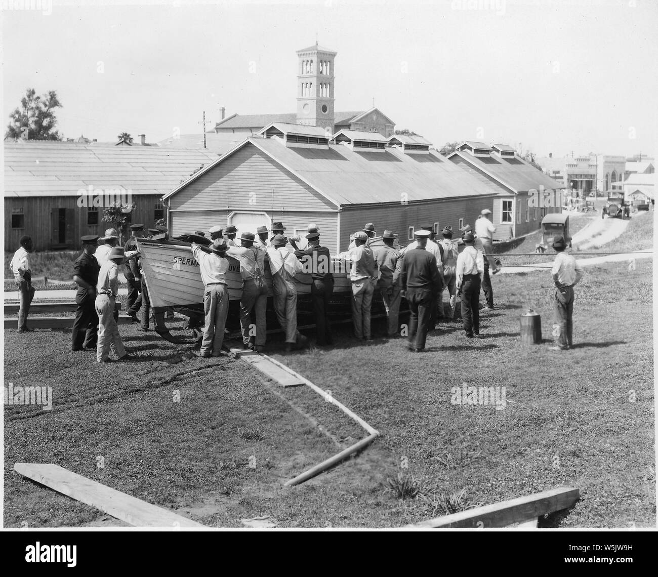 Group of men standing around Black and White Stock Photos & Images - Alamy