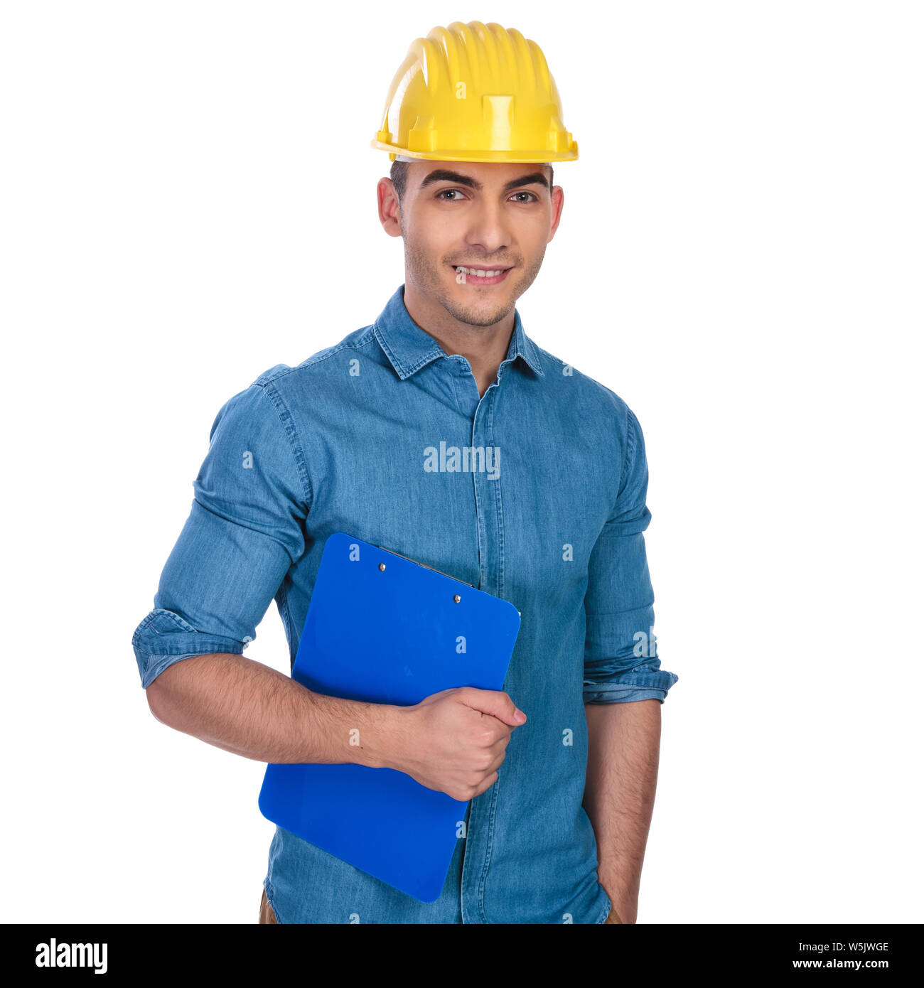 portrait of relaxed engineer wearing hard cap and holding papers while ...