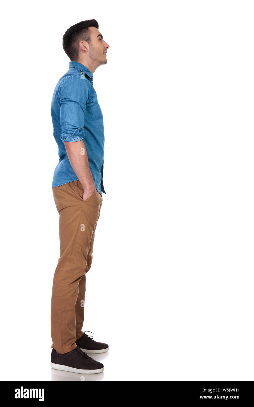 side view of relaxed casual man looking up at something while standing ...