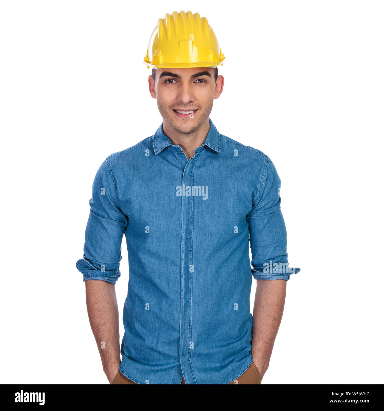 portrait of young and relaxed engineer student wearing yellow helmet ...