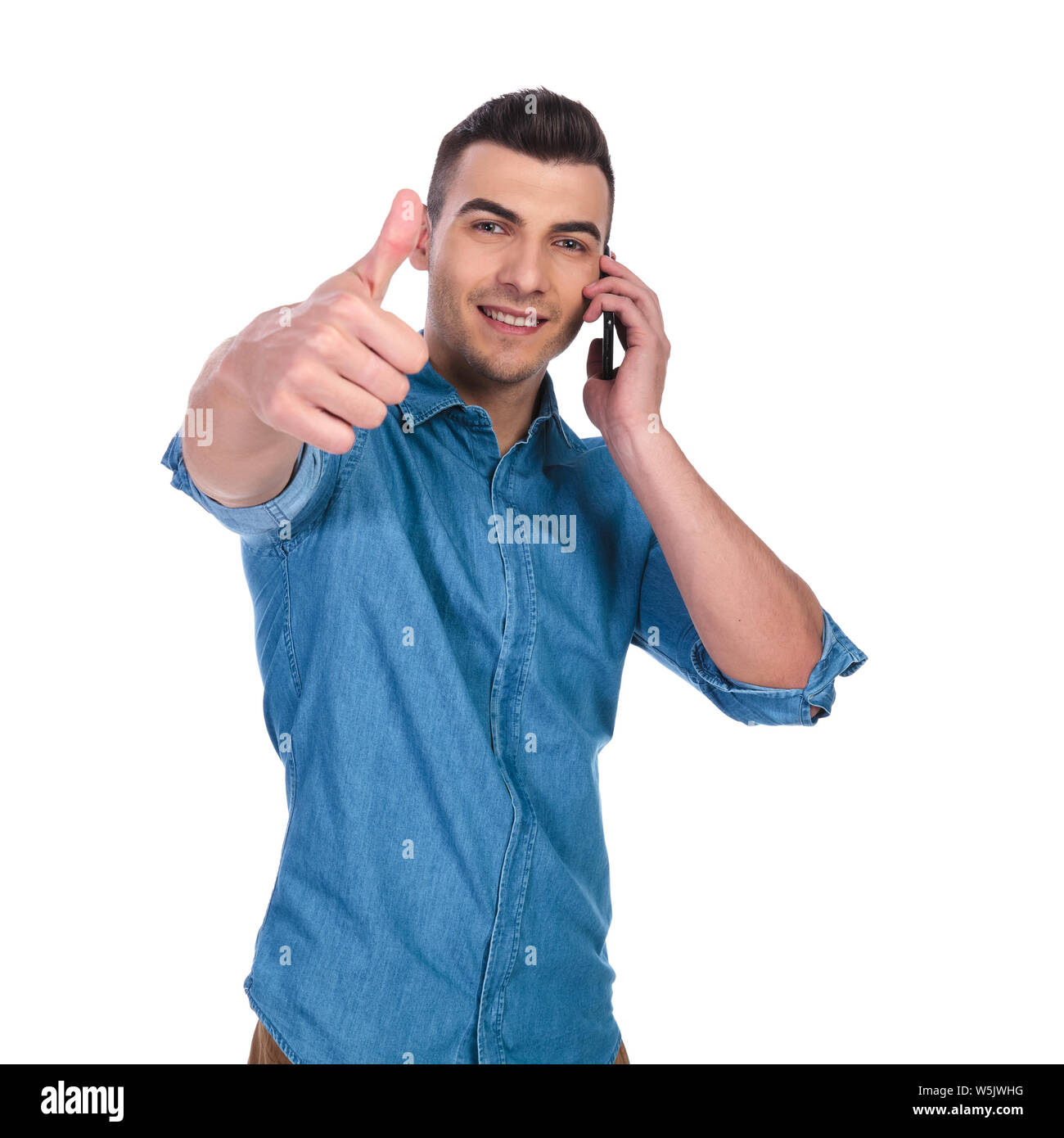portrait of attractive young man speaking on the phone and making ok ...