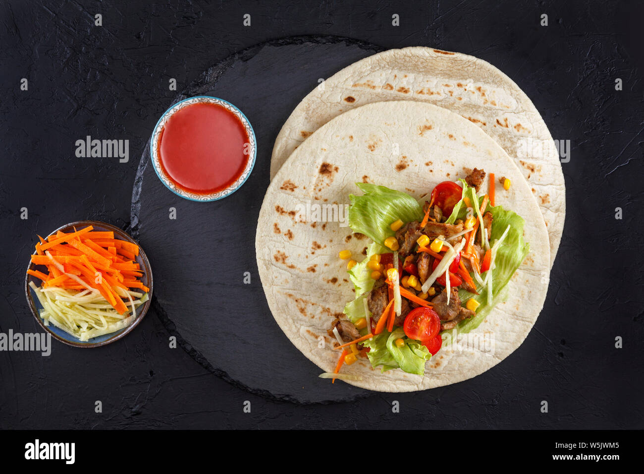 Burritos wraps with chicken and vegetables on black slate. Chicken burrito, mexican food Stock ...