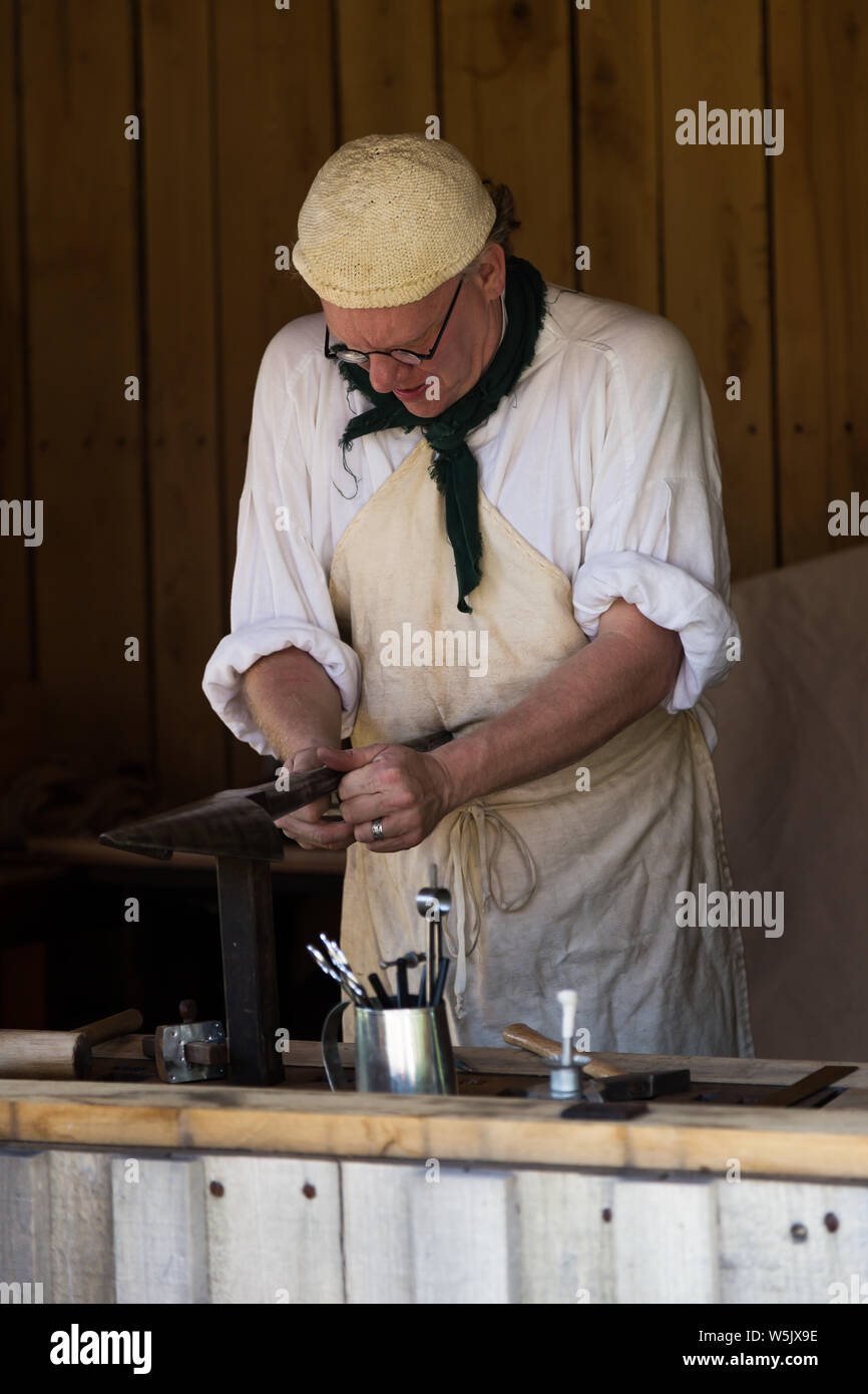 A reenactor demonstrates the skill of a tinsmith at Historic Old Fort ...