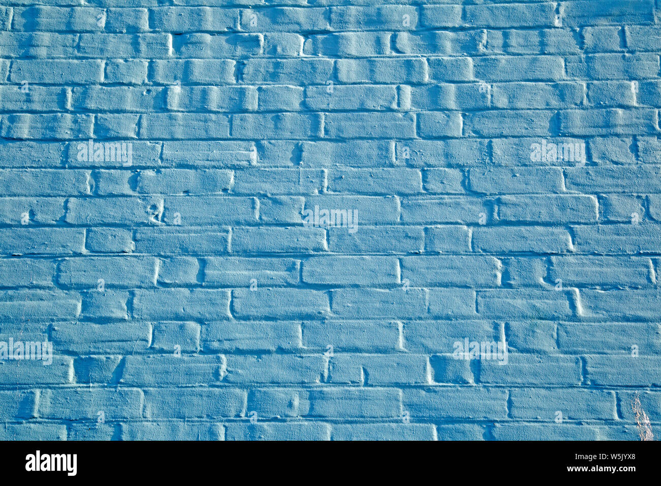 Blue painted brick wall shot in raking sunlight to show texture Stock ...