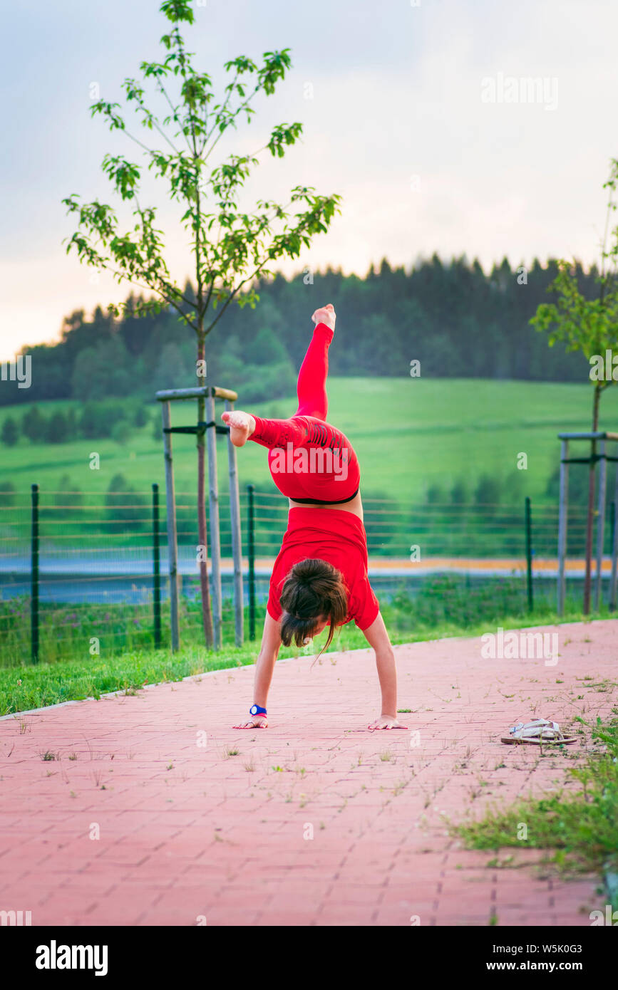 A girl does acrobatic stunts on the street.Girl acrobatics on the ...