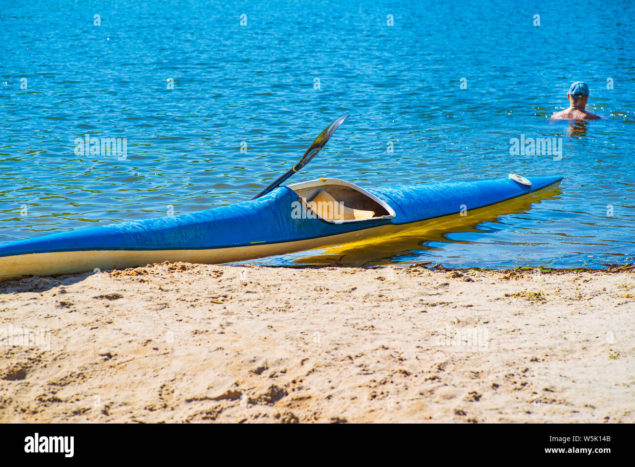 Kayak on the beach. Kayak blue and yellow. Boat on the river bank ...