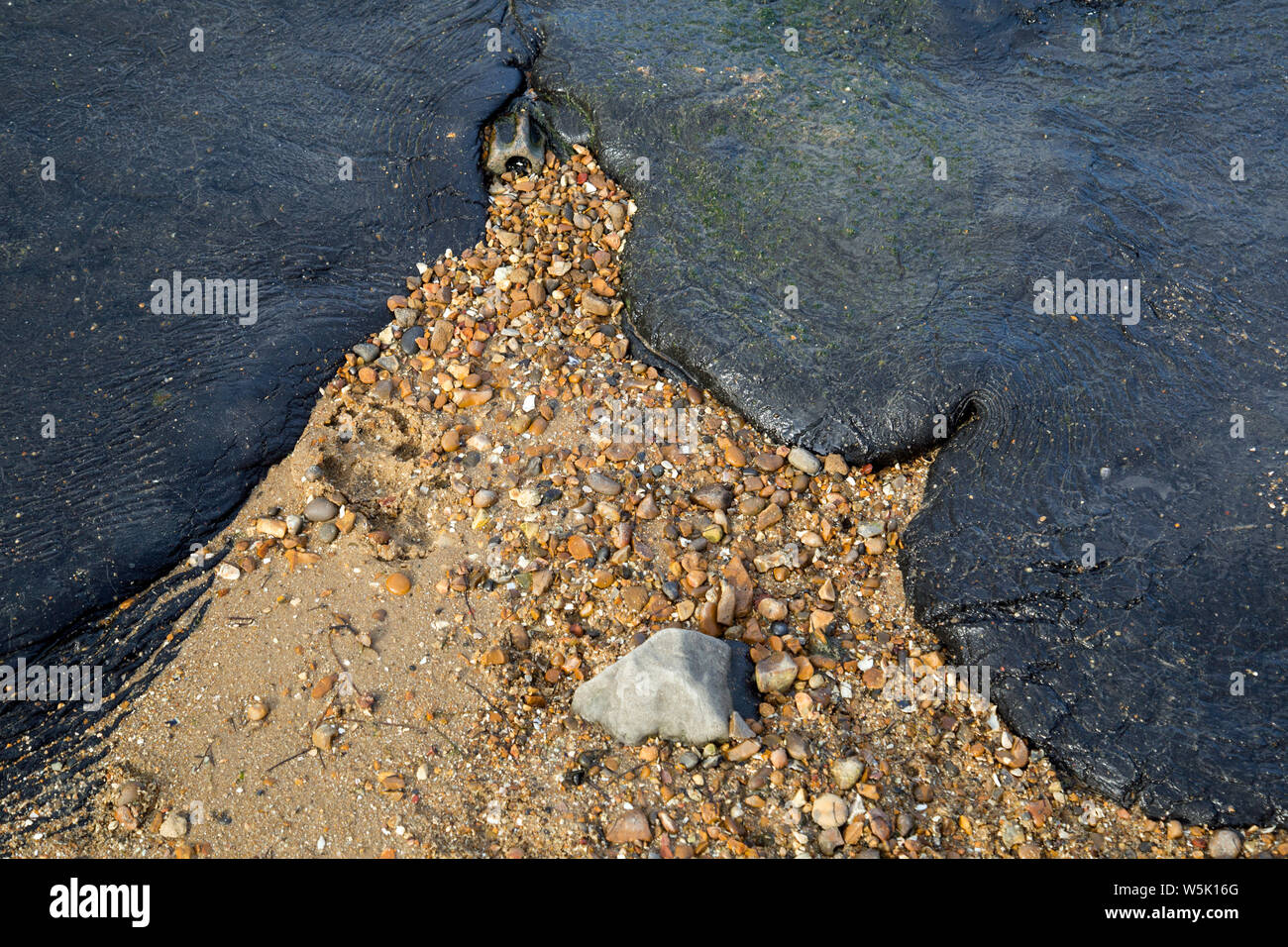 A gap in tar at the beach where sand and grit has accumulated Stock ...