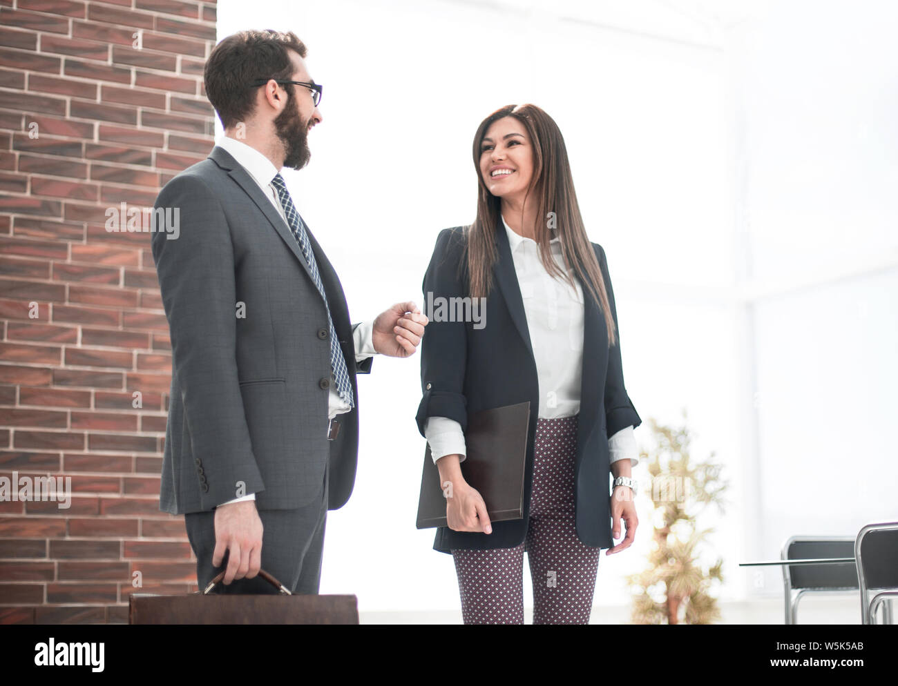 two employees talking standing in the office Stock Photo - Alamy