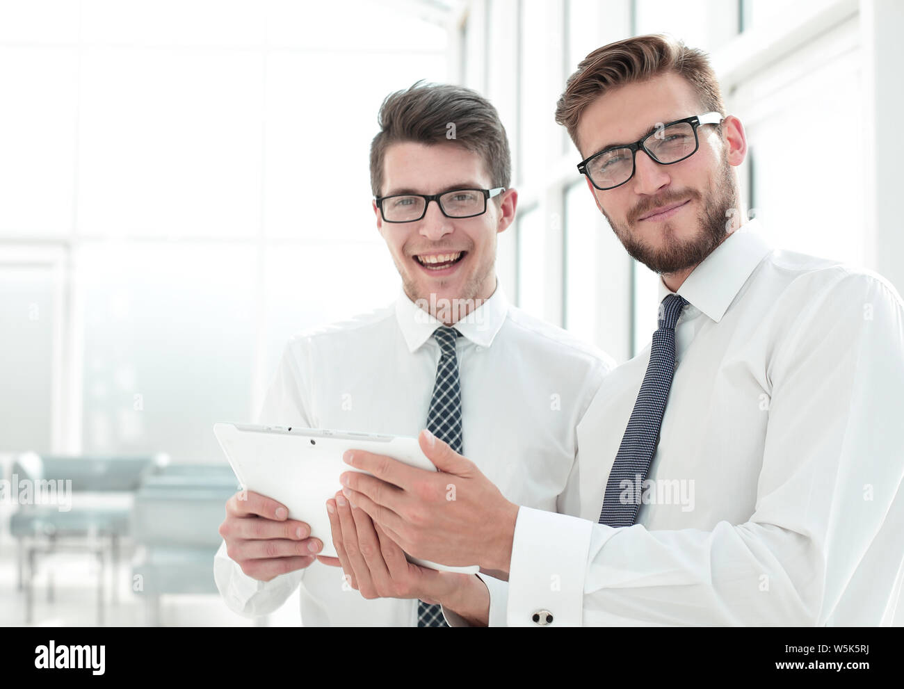 close up.employees with a digital tablet standing near the office ...