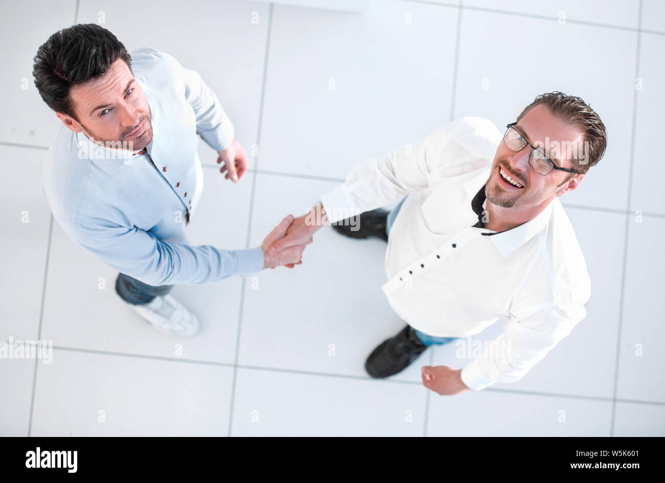 top view. smiling businessmen shake hands Stock Photo - Alamy