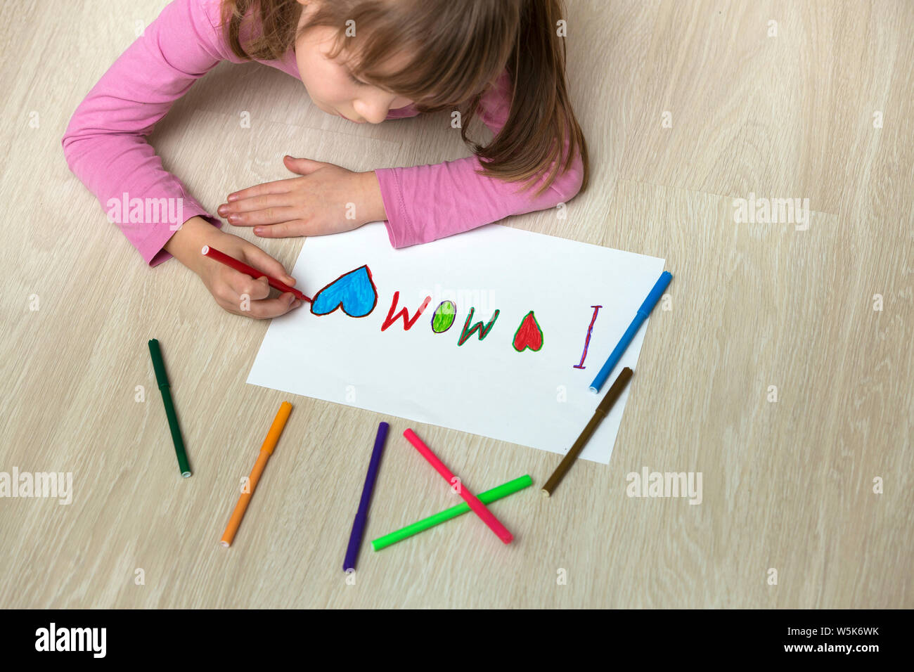 View from above of cute child girl drawing with colorful crayons I love ...