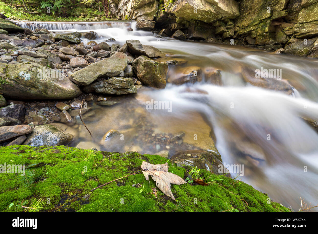 Fast flowing river stream with smooth silky water falling from big ...