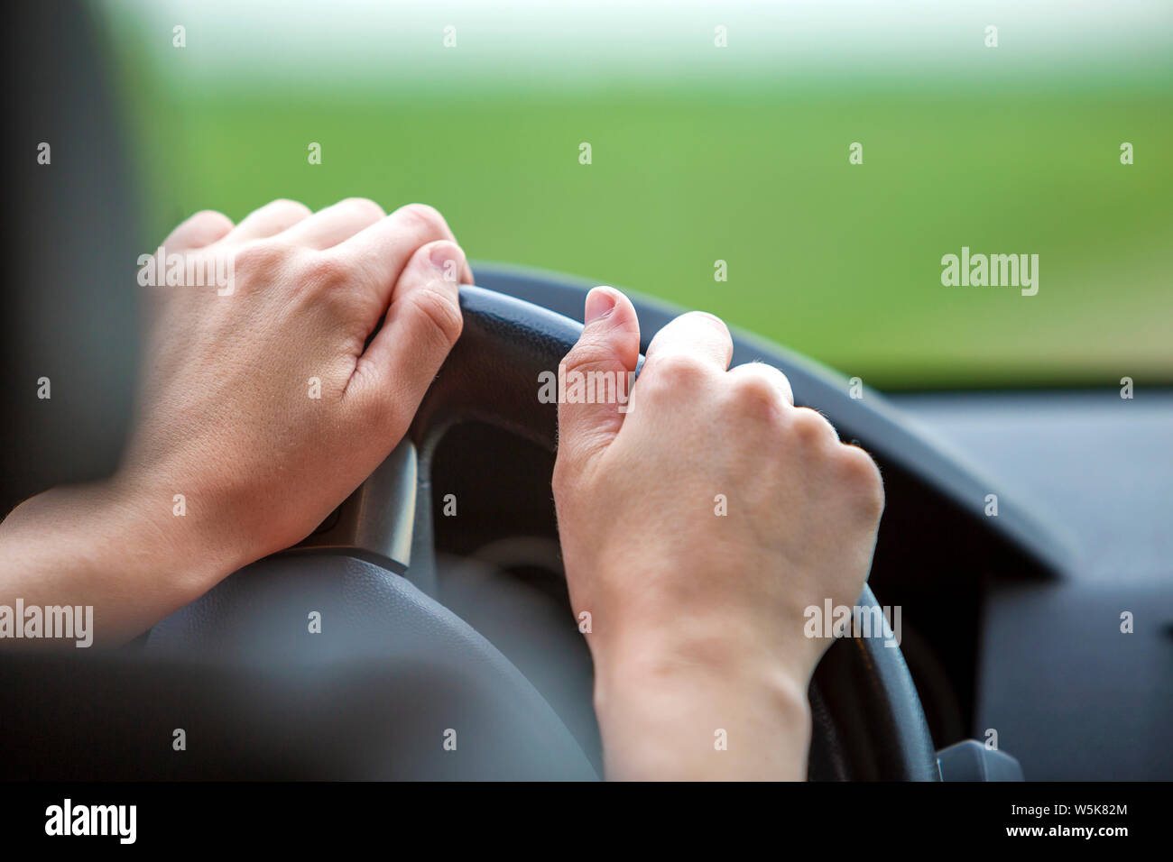 Woman hands on steering wheel driving a car Stock Photo - Alamy