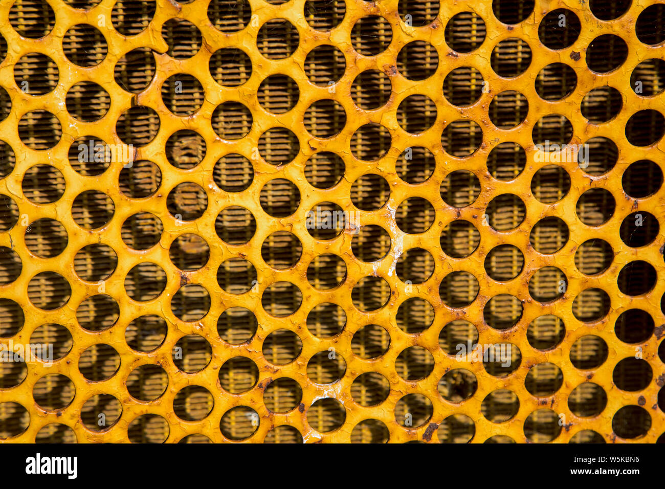 Close up on a yellow metal radiator grille for use as a background ...