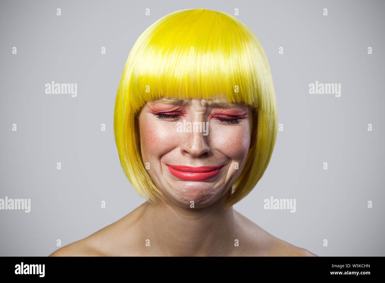 Portrait of sad alone cute young woman with freckles, red makeup and ...