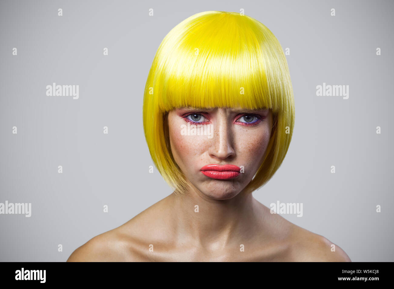 Portrait of unhappy alone cute young woman with freckles, red makeup ...
