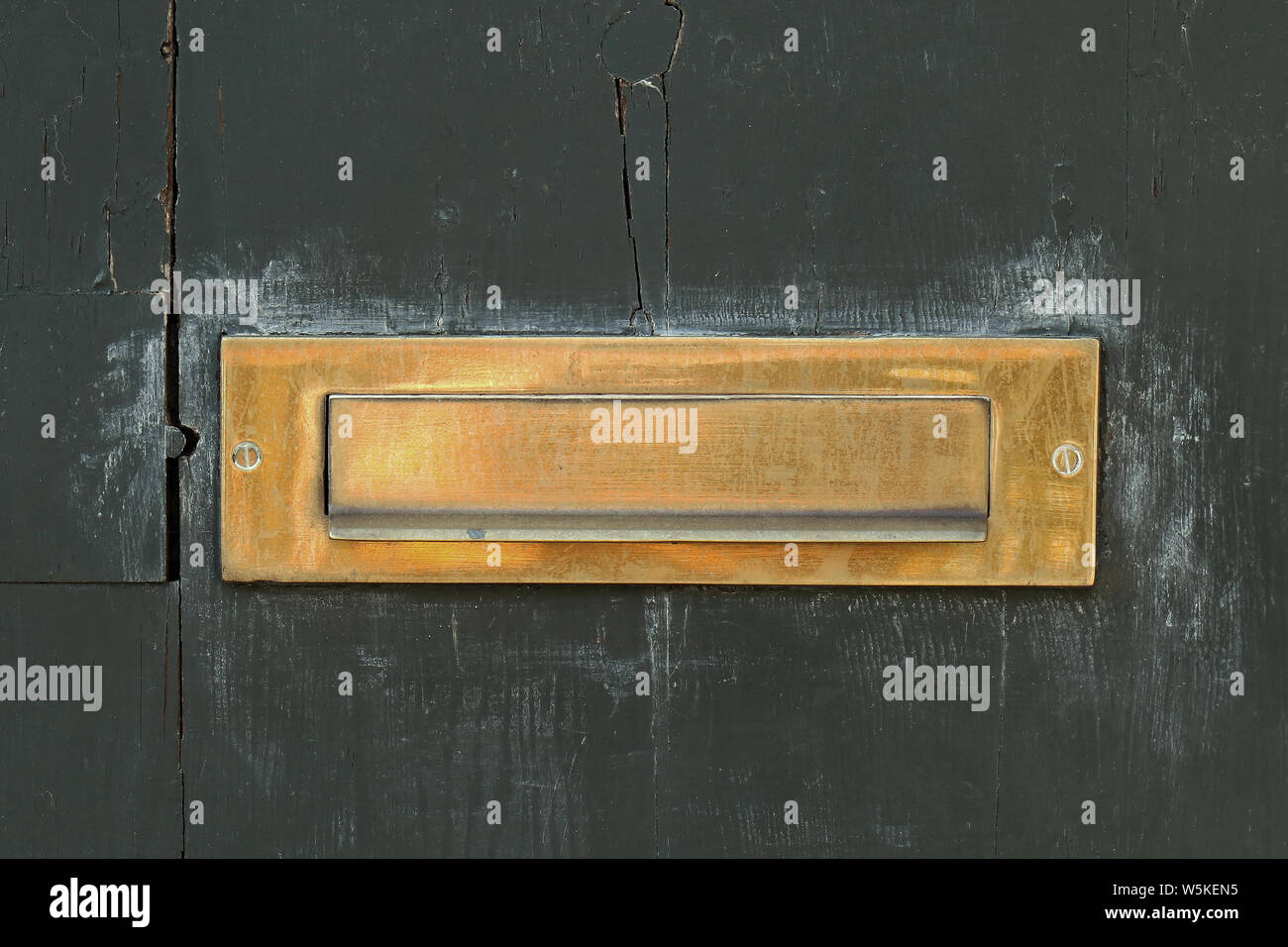 Old golden metal mail slot on wooden door exterior Stock Photo - Alamy