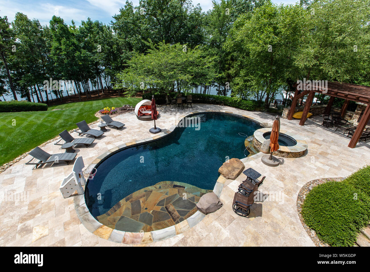 Luxurious outdoor pool with landscaping, in the backyard of a home ...