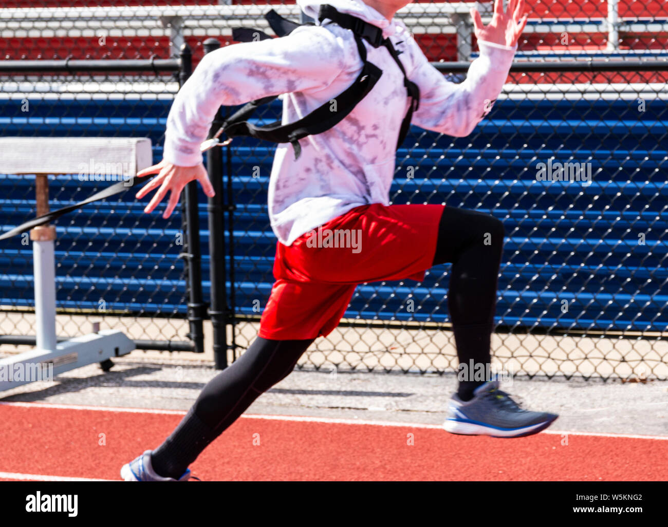 High school track and field runner is sprinting while strapped up to ...