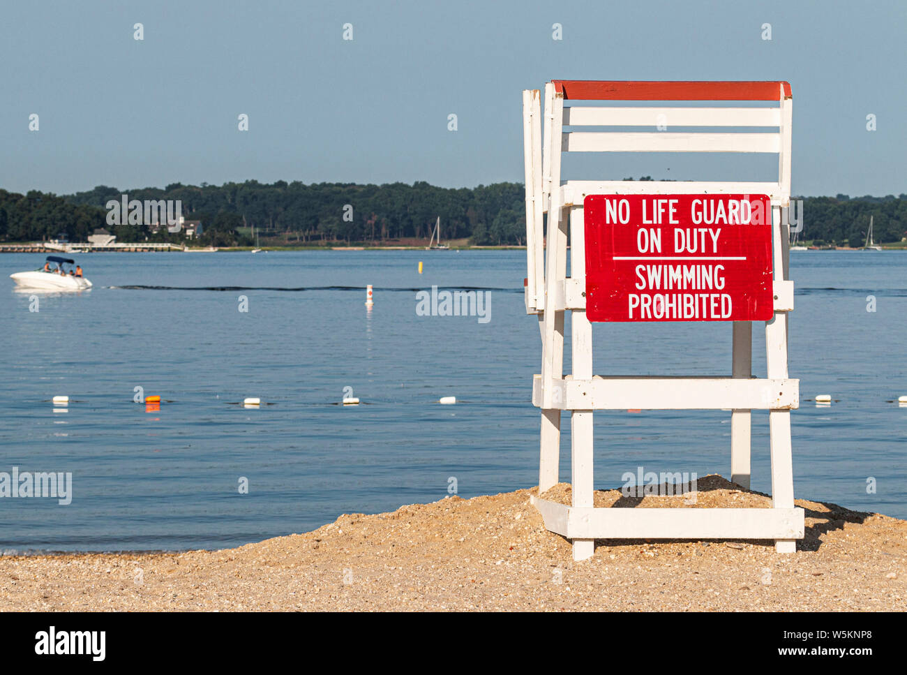 An empty lifeguard stand with a sign that saying no life guard on duty ...