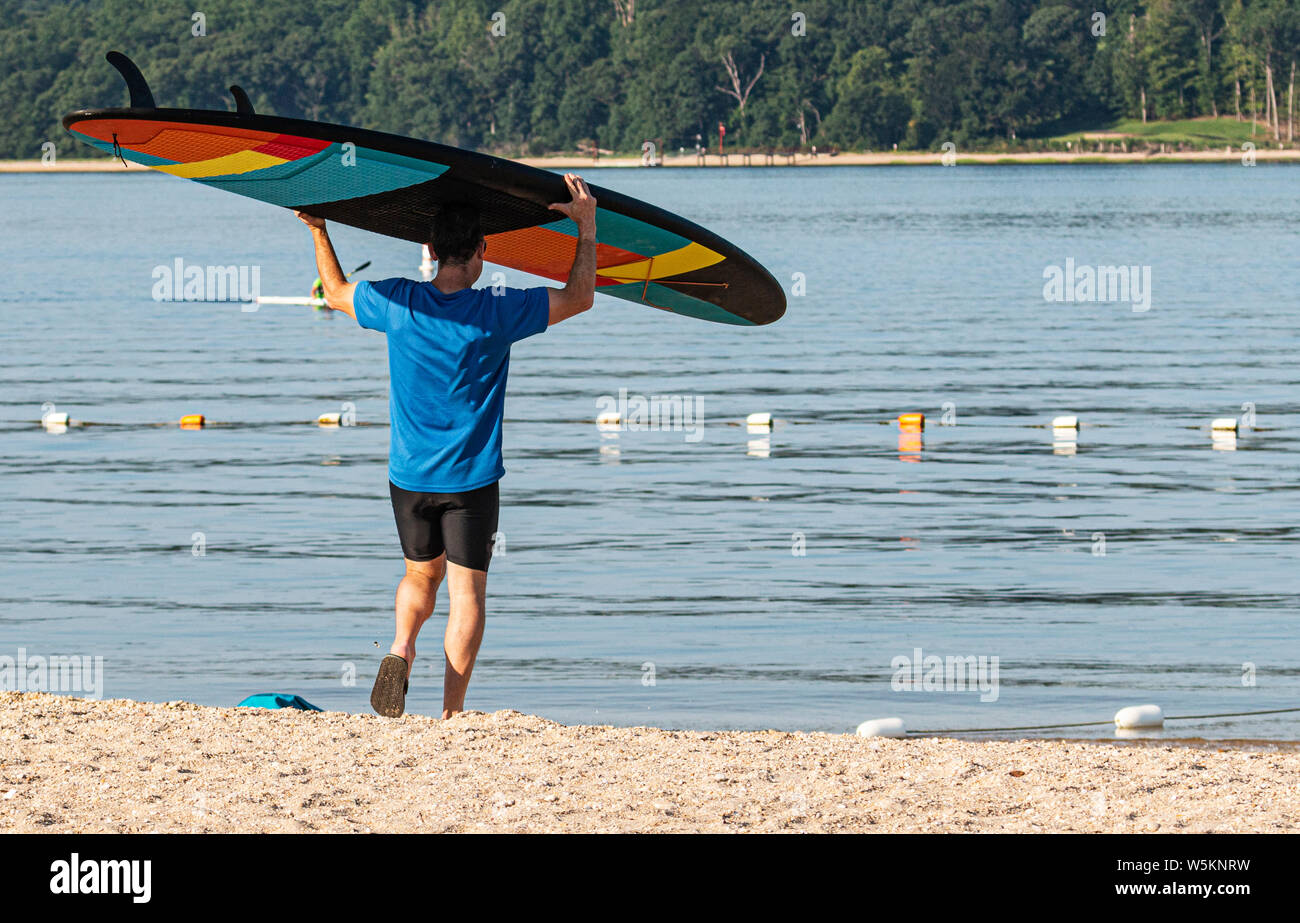 Man carrying paddle board hi-res stock photography and images - Alamy