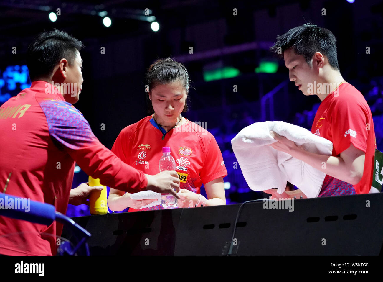Fan Zhendong and Ding Ning of China talk to their coach Wang Hao as ...