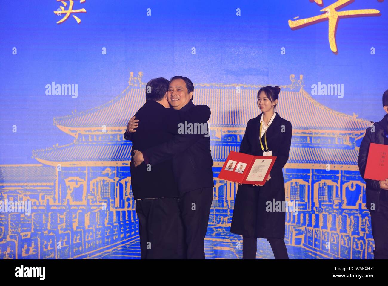Shan Jixiang, left, the museum curator, issues the certificate for a ...