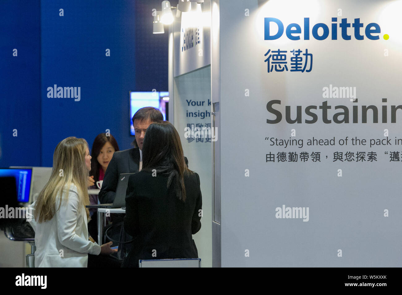 --FILE--People visit the stand of Deloitte during an exhibition in Hong ...