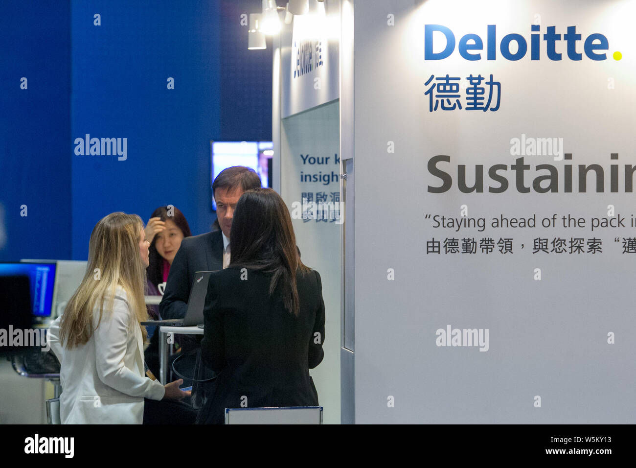 --FILE--People visit the stand of Deloitte during an exhibition in Hong ...