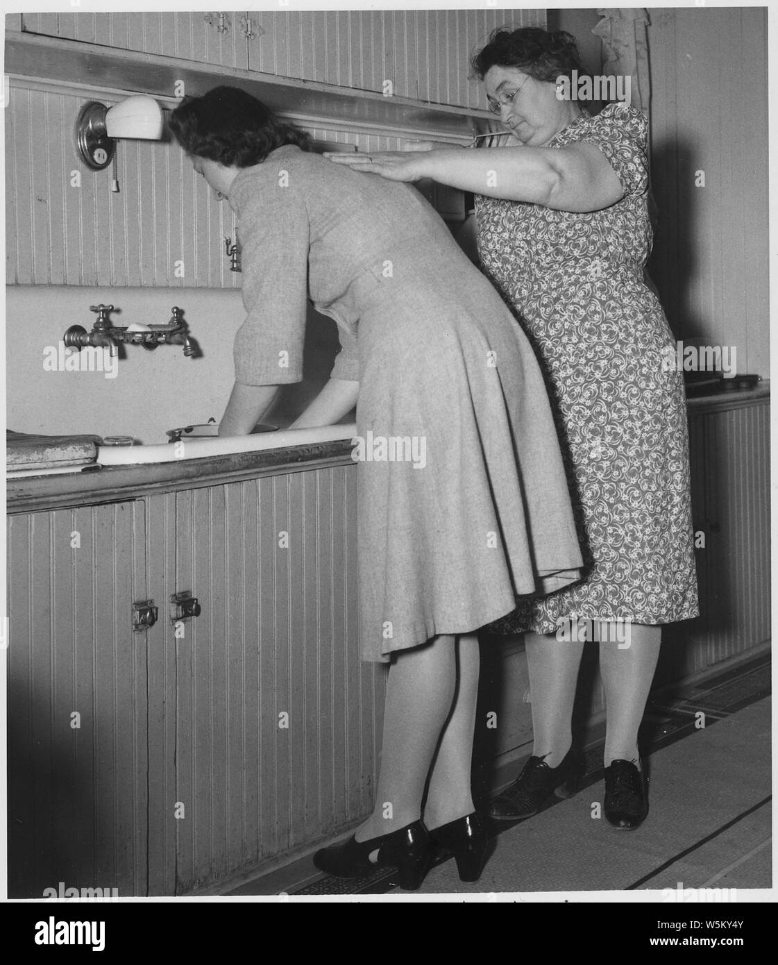 Demonstrating to each other correct posture in housework Stock Photo ...
