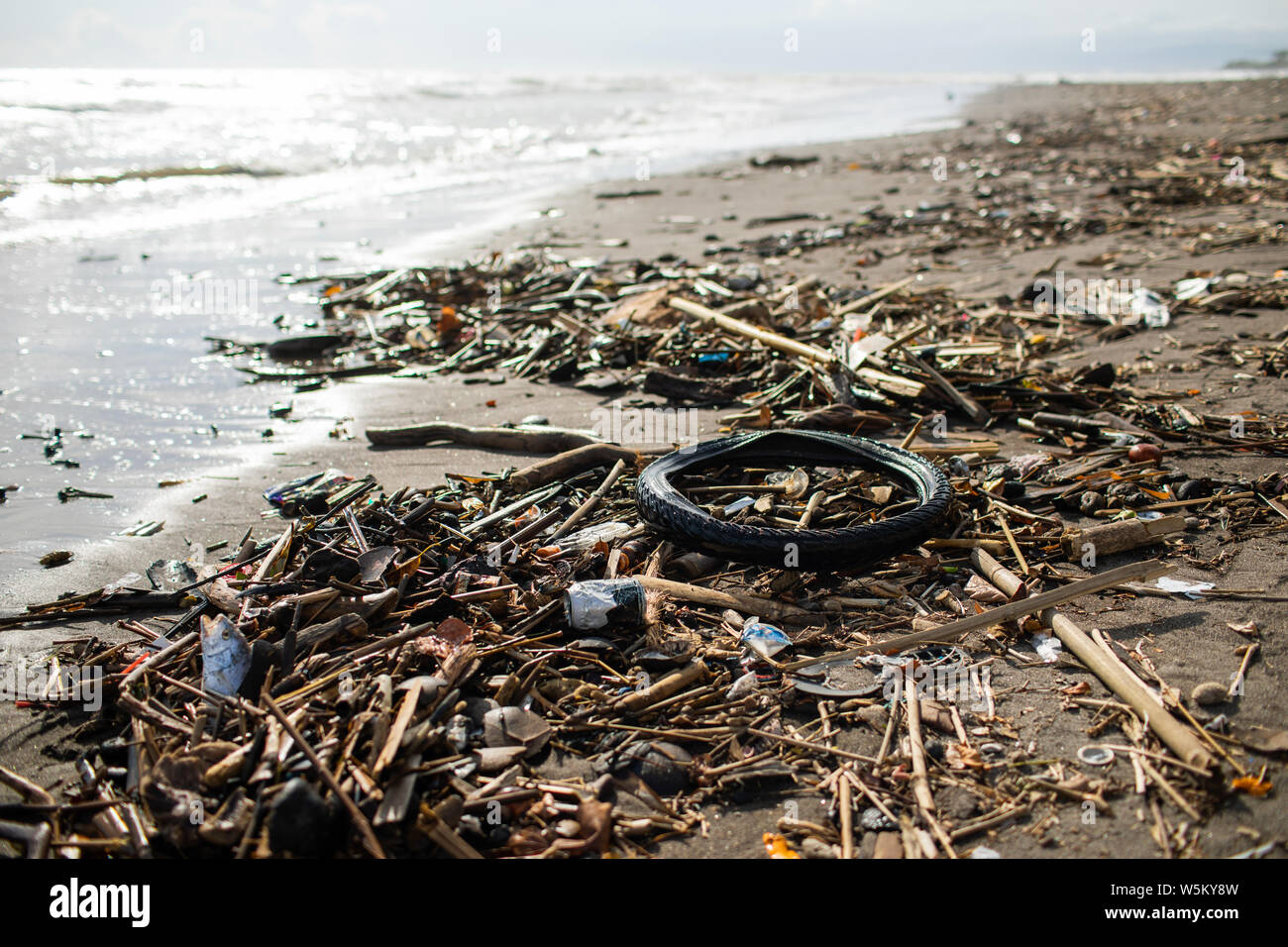 Beach pollution with plastic bottles, rubber tyre and other waste in ...