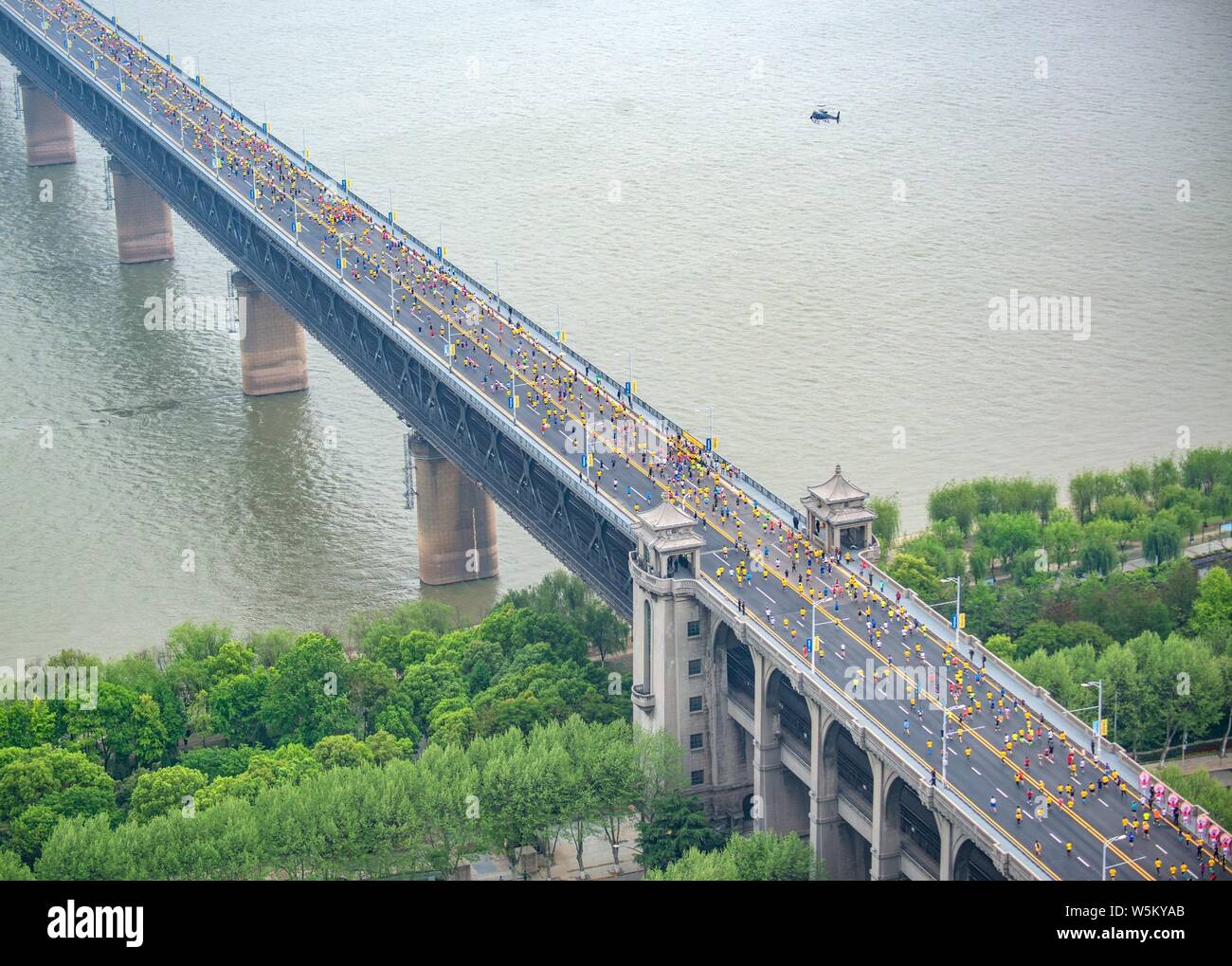 Participants pass over the Wuhan Yangtze River Bridge during the 2019 ...