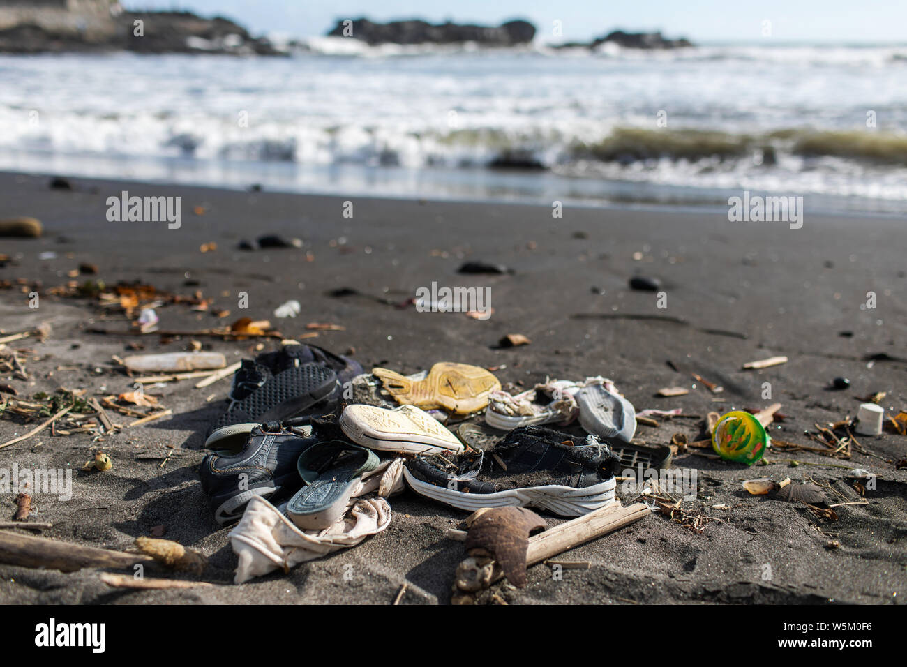 Environmental pollution. Heap of used rubber shoes on the beach in Bali ...