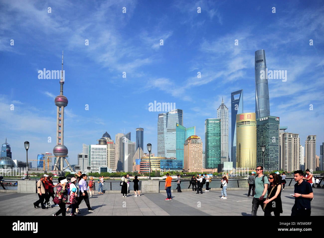 Pedestrians walk under the hot weather at the Bund or Waitan in ...