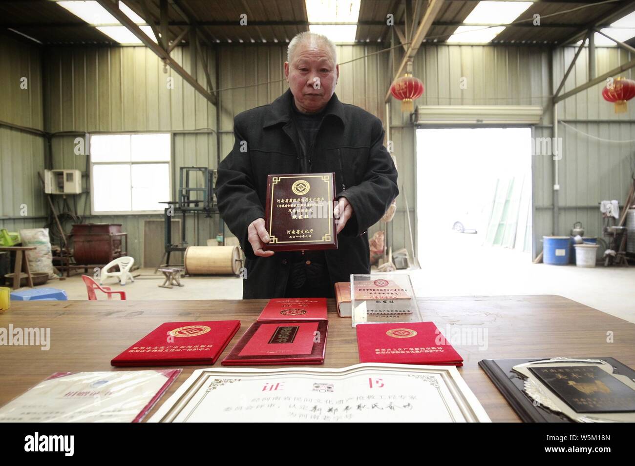 70-year-old Chinese elderly man Geng Fawang shows certificates ...