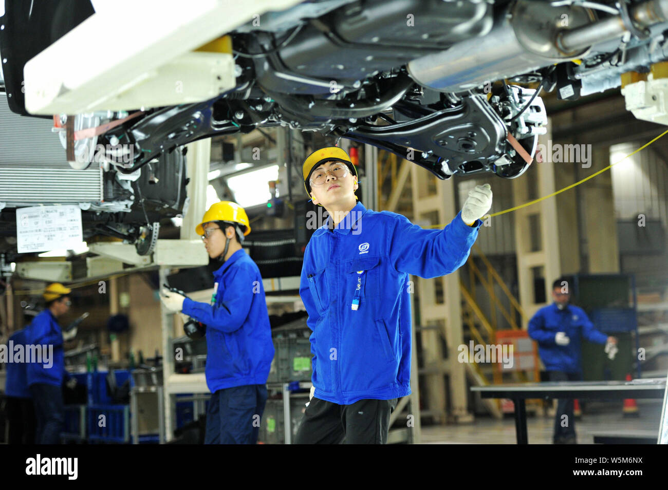Chinese workers assemble cars on the assembly line at the auto plant of ...