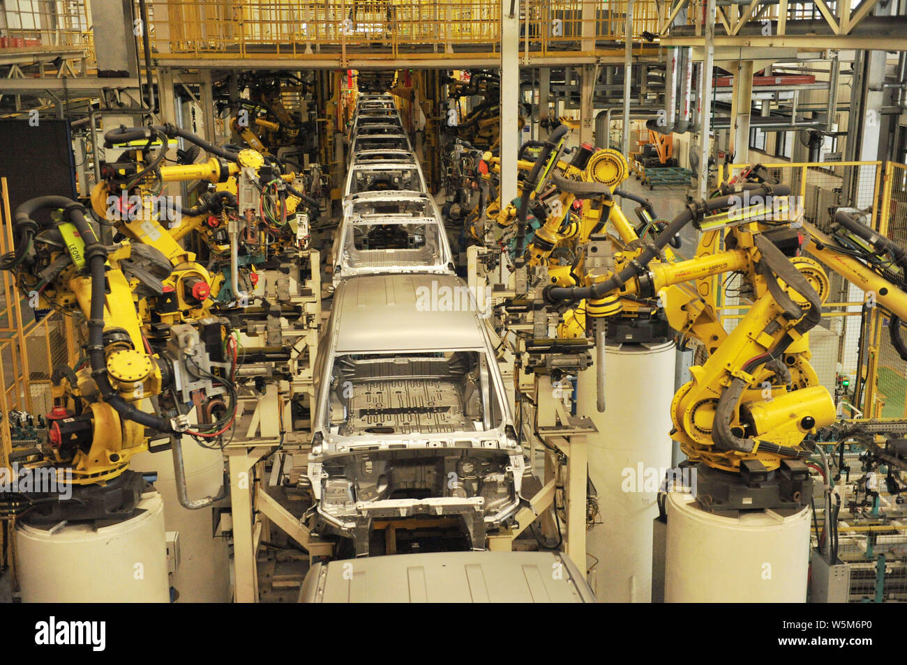 Chinese workers assemble cars on the assembly line at the auto plant of ...