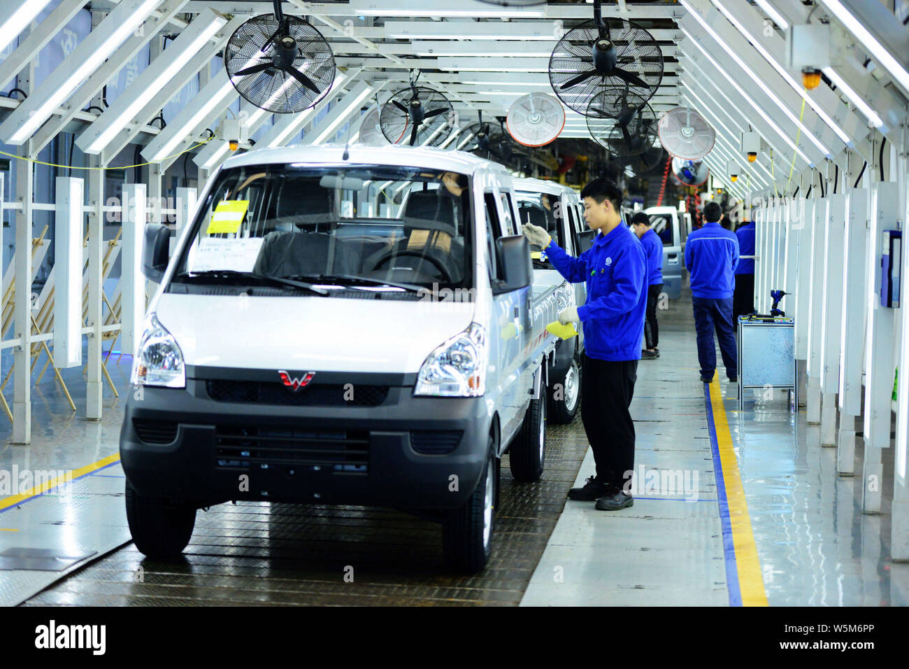 Chinese workers assemble cars on the assembly line at the auto plant of ...