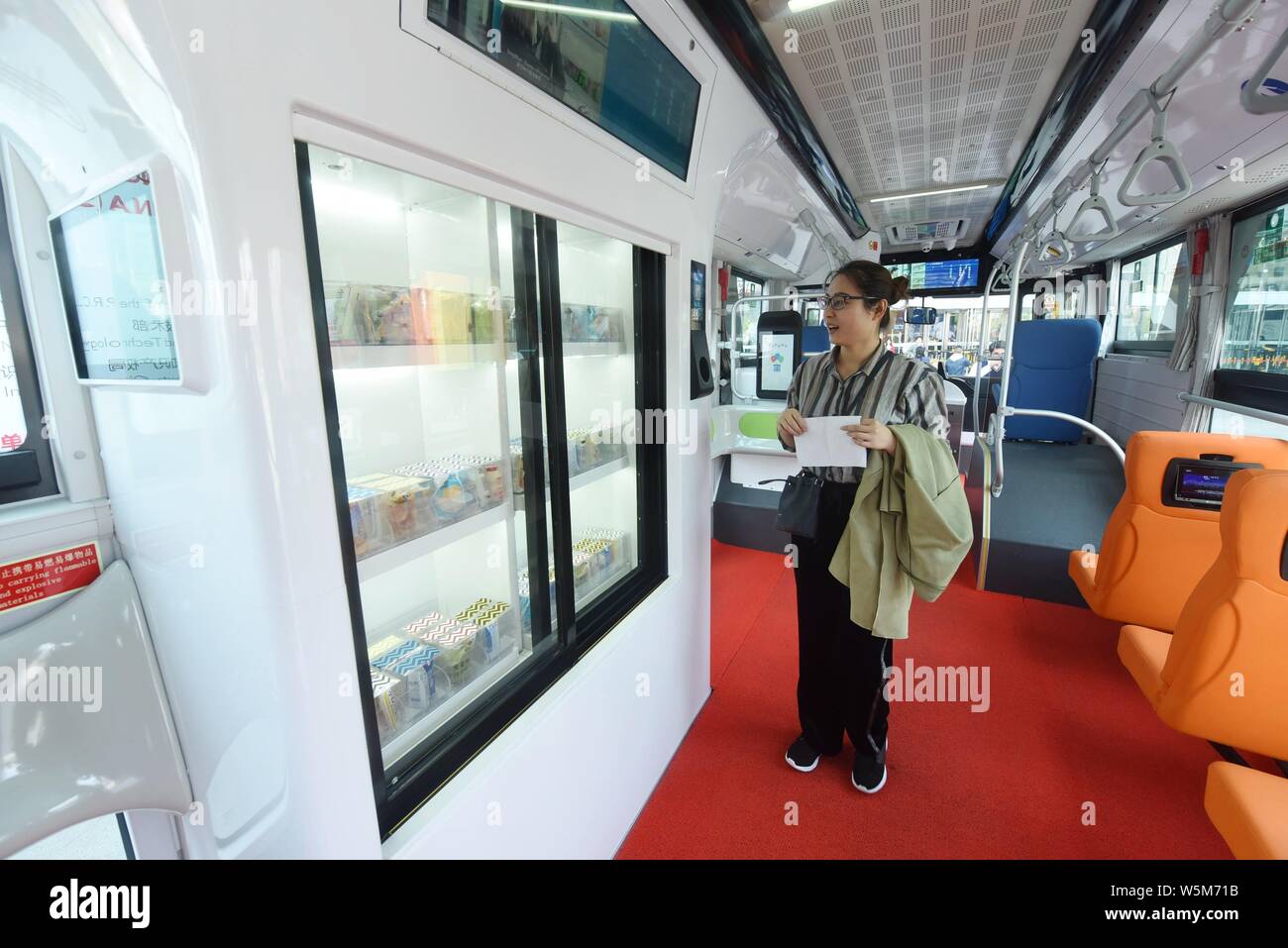 A woman visits a Smart Panda Bus autonomous vehicle developed by ...
