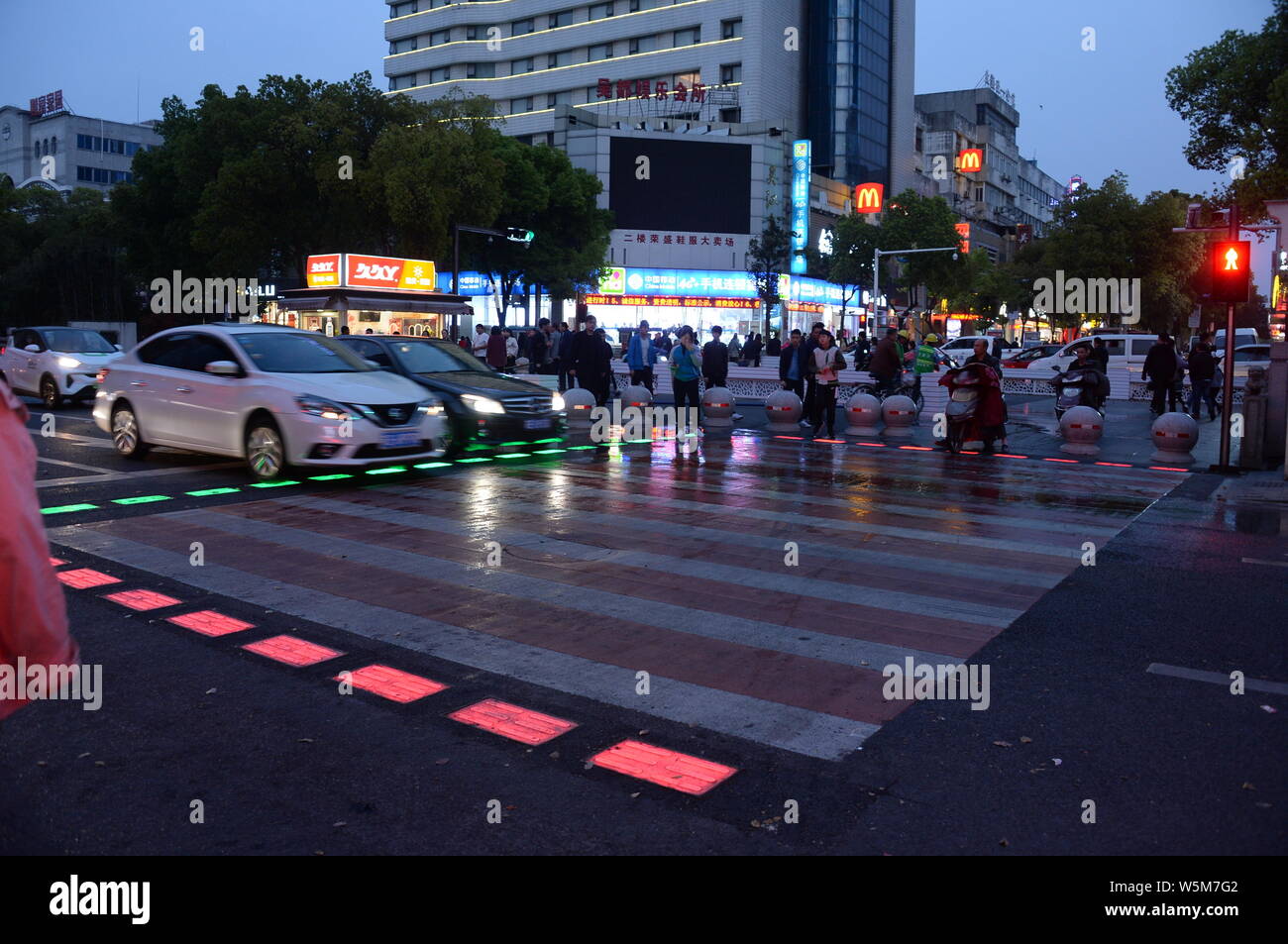 Pedestrians walk on a smart zebra crossing backed by automatic sensors ...