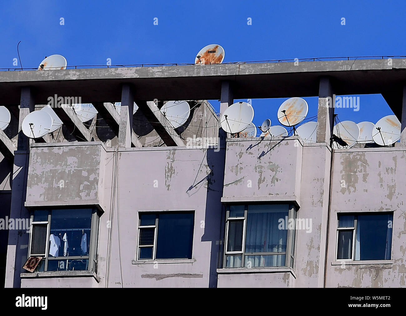 A residential building is installed with satellite TV receiver dishes ...