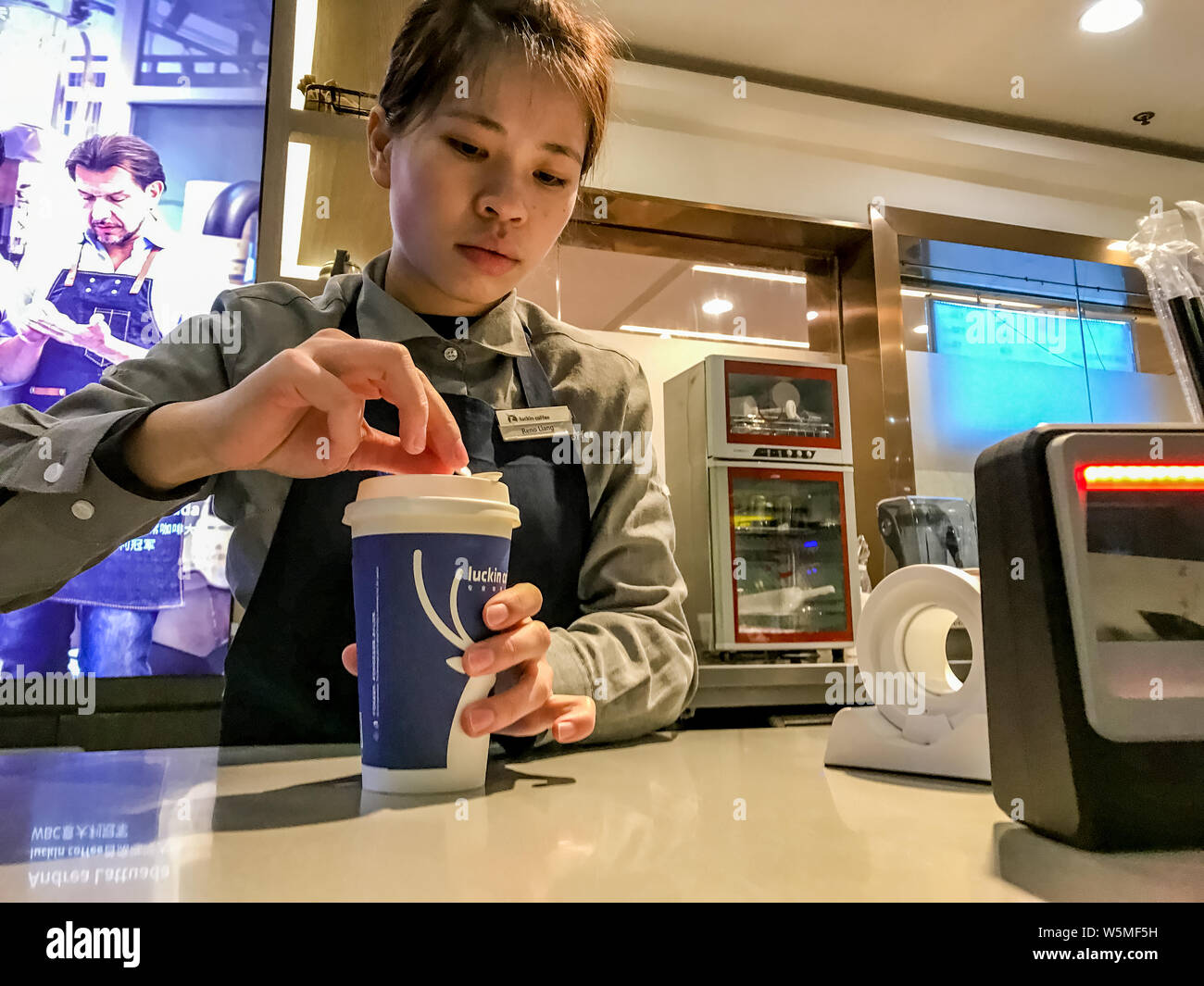 --FILE--A Chinese employee makes a cup of Luckin Coffee for a customer ...