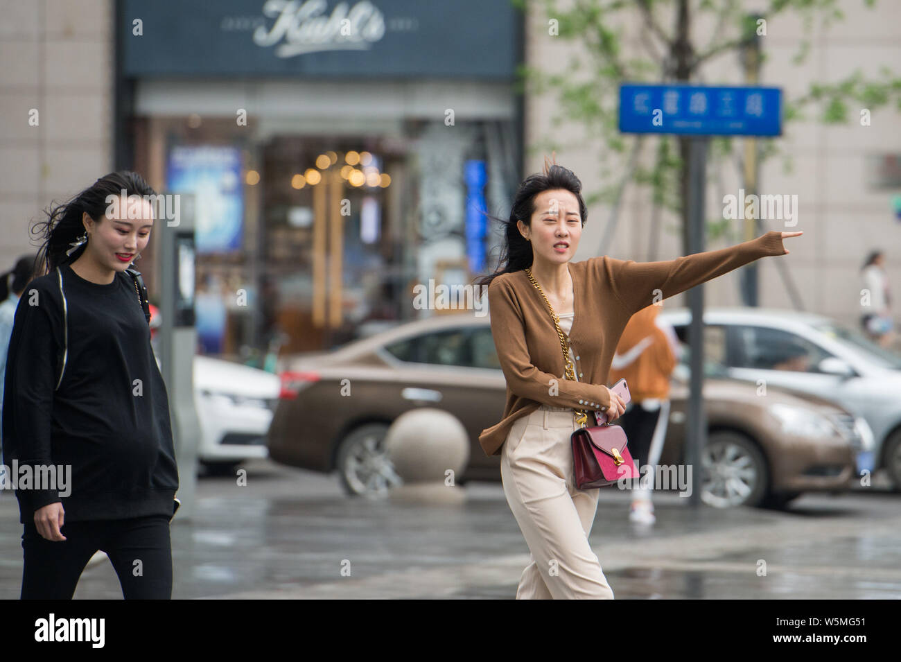 High wind tumbles people's hair as wind and temperature fall hit ...