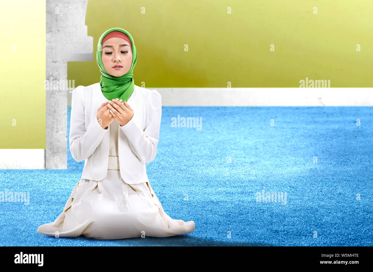 Asian Muslim woman sitting in pray position while raised hands and ...