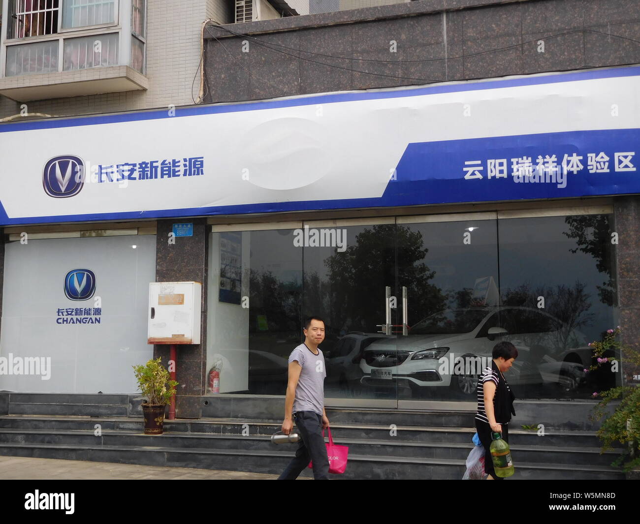 --FILE--Pedestrians walk past a dealership store of Changan Automobile ...