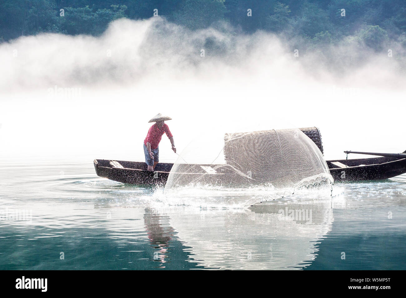In this undated photo, a Chinese fisherman harvests fish along the ...