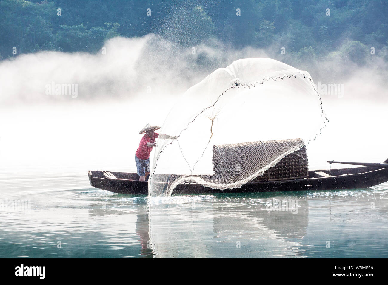 In this undated photo, a Chinese fisherman harvests fish along the ...