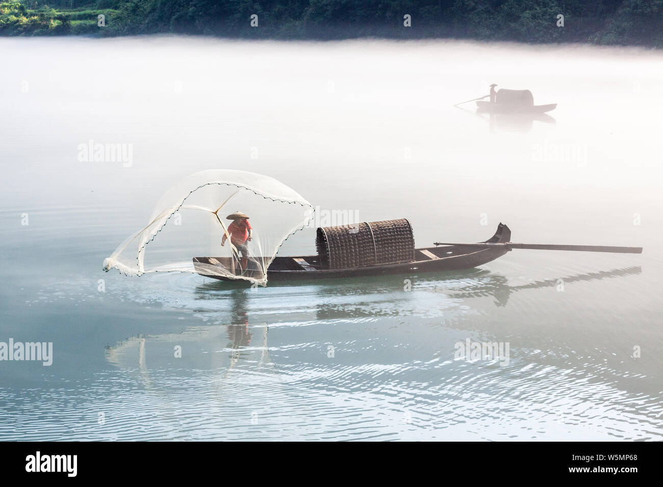 In this undated photo, a Chinese fisherman harvests fish along the ...
